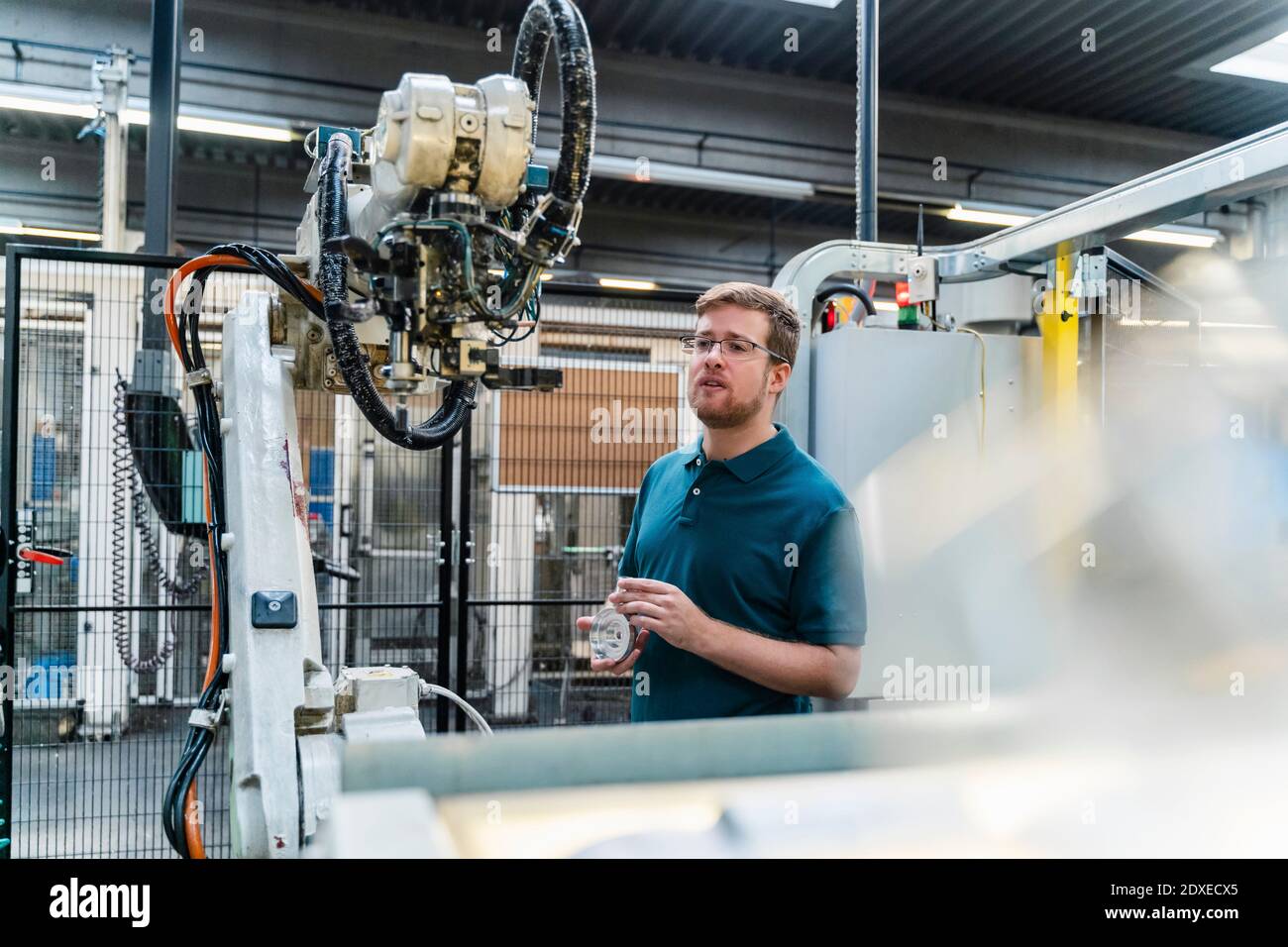 Male factory worker analyzing while standing at manufacturing industry ...