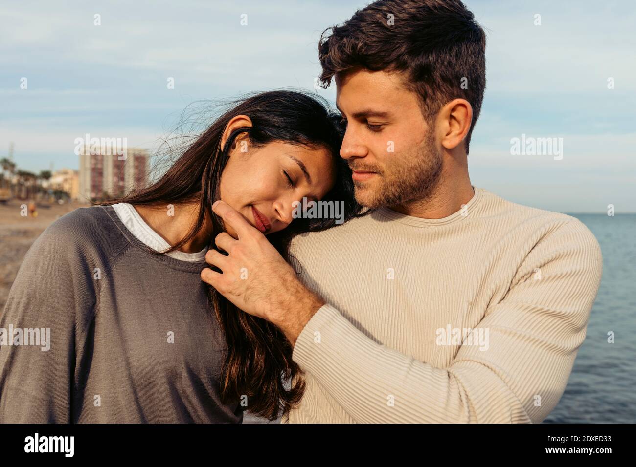 Boyfriend looking at girlfriend leaning on his shoulder at beach Stock ...