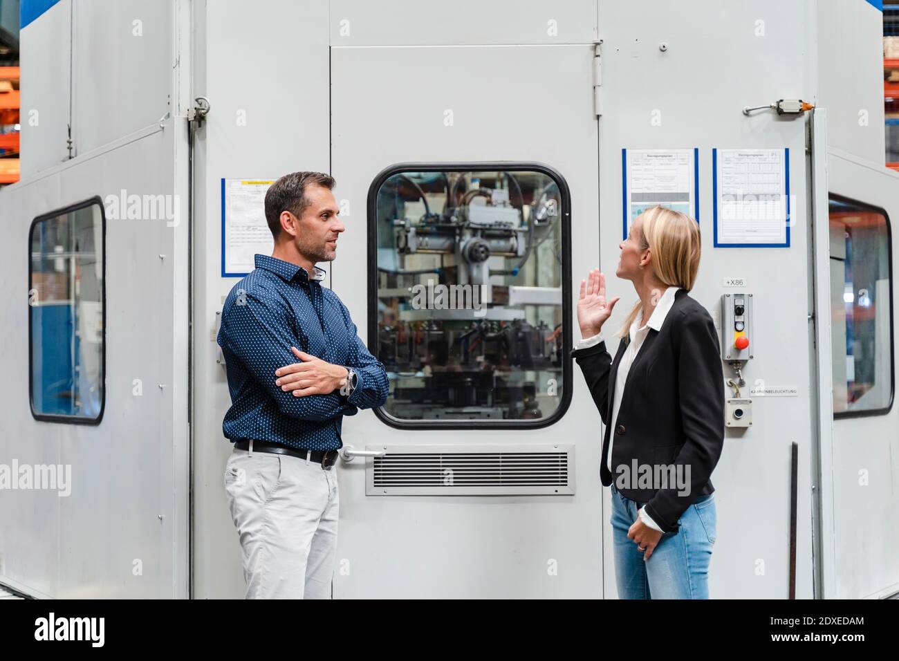 Businesswoman explaining male colleague while standing by control room ...