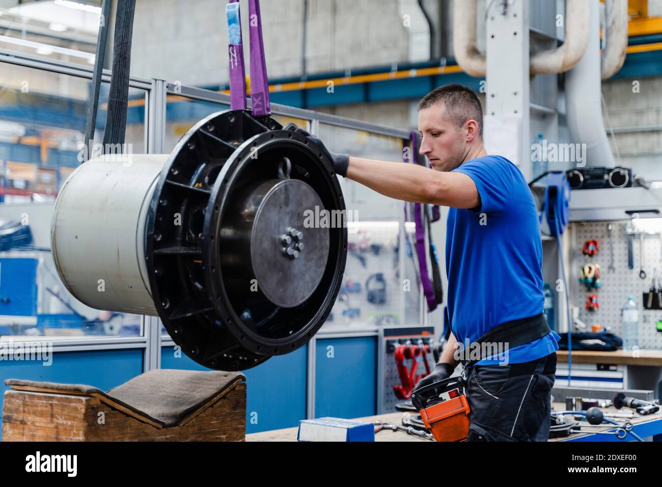 Professional male engineer analyzing machinery in industrial factory ...