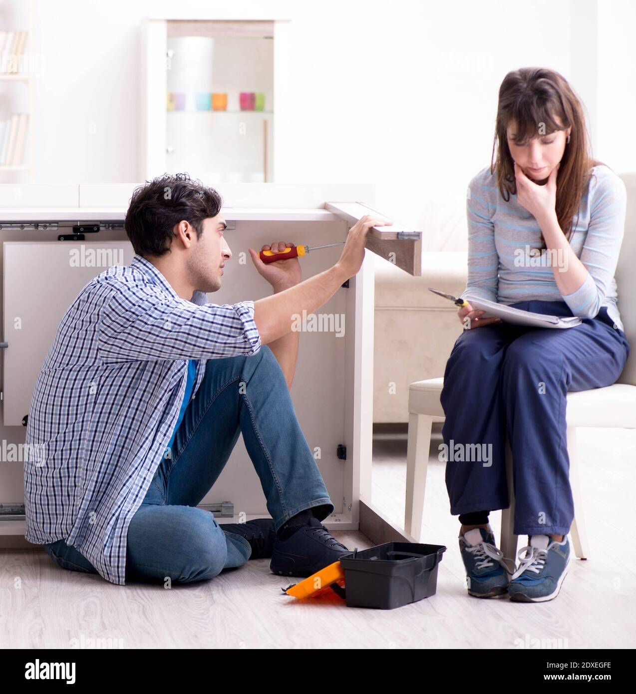 The husband repairing broken table at home Stock Photo - Alamy