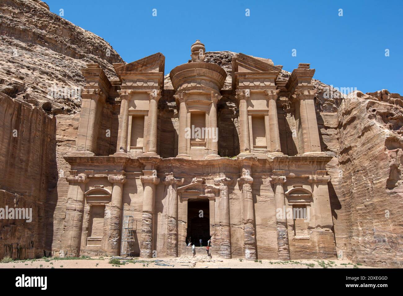 Tourists climb into the huge doorway of the Monastery at the ancient ...