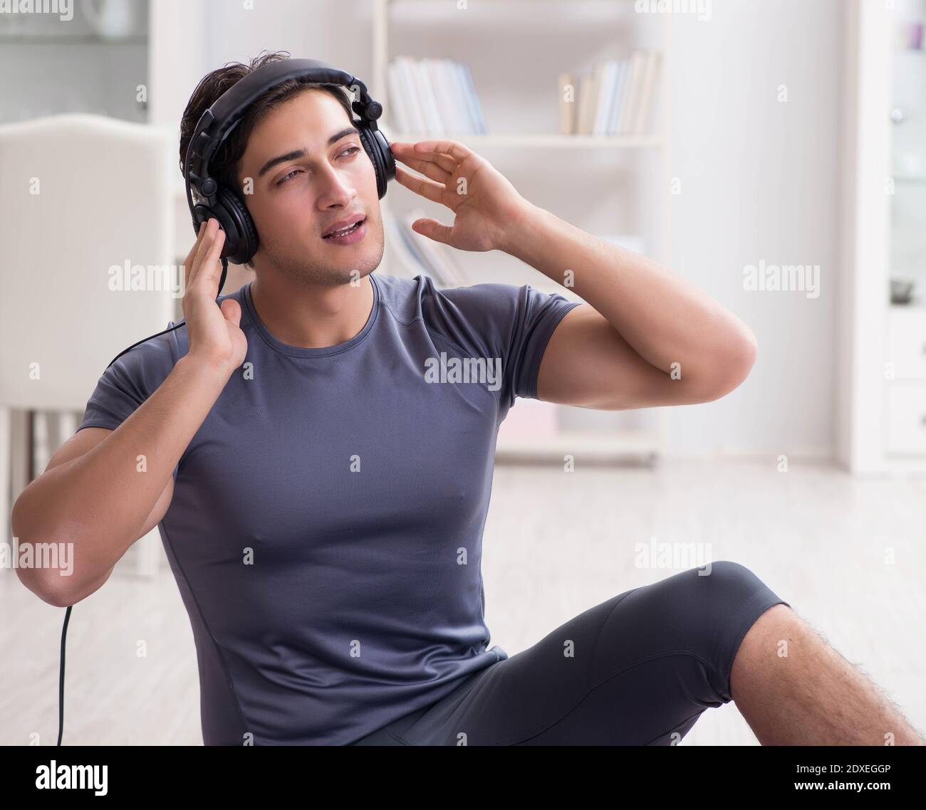 The man doing sports at home and listening to music Stock Photo - Alamy