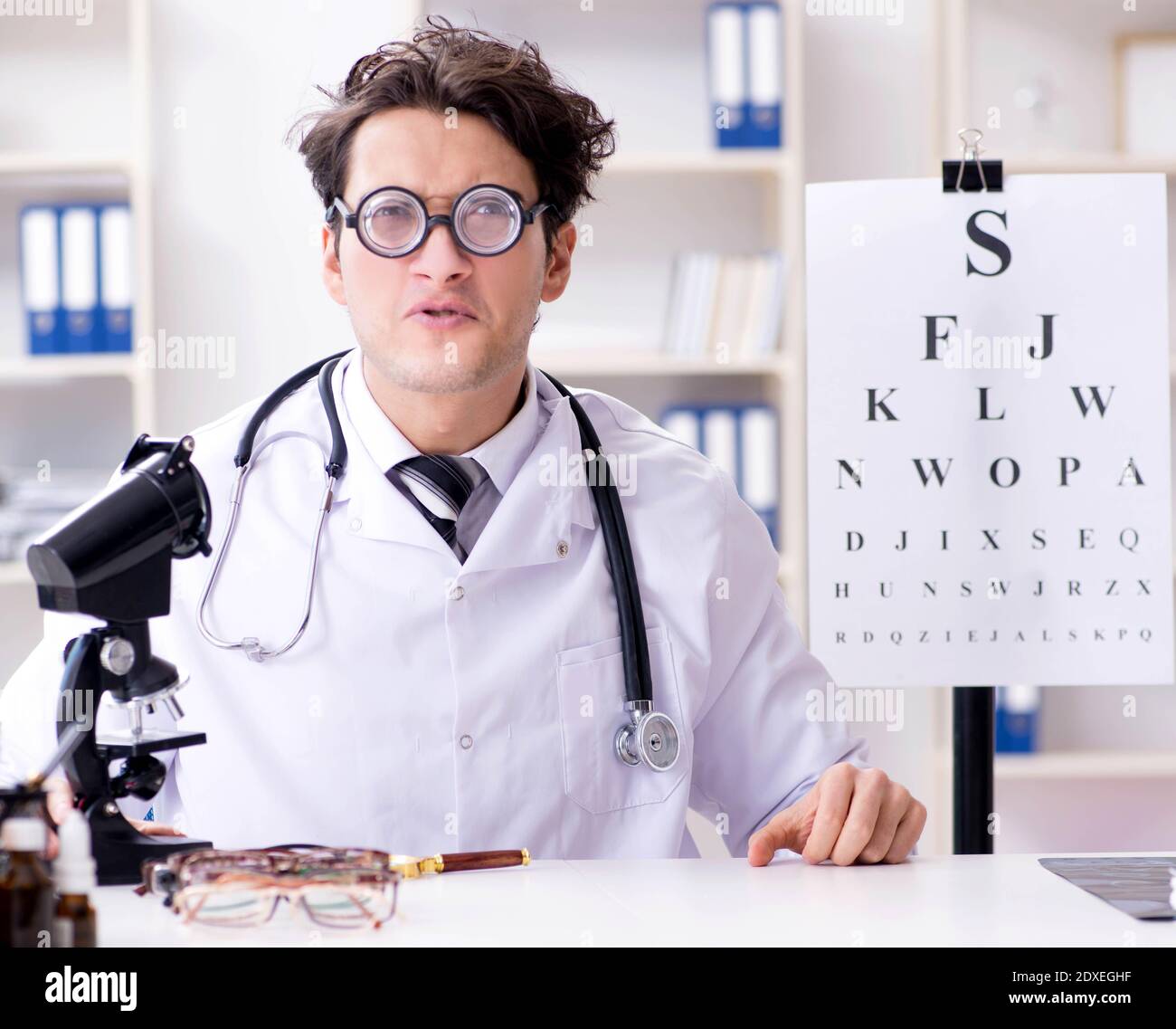 The funny eye doctor in humourous medical concept Stock Photo - Alamy