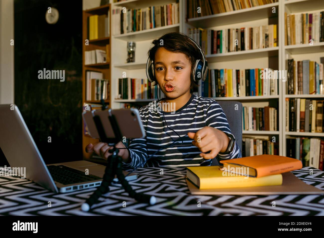 Boy vlogging with smart phone at table in living room Stock Photo - Alamy