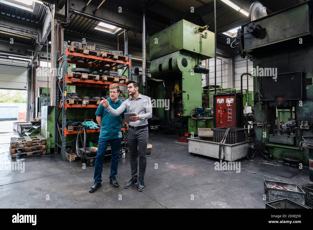 Male coworkers pointing while standing in manufacturing industry Stock ...