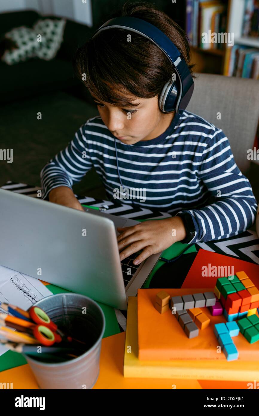 Pre-adolescent boy using laptop during homeschooling Stock Photo - Alamy