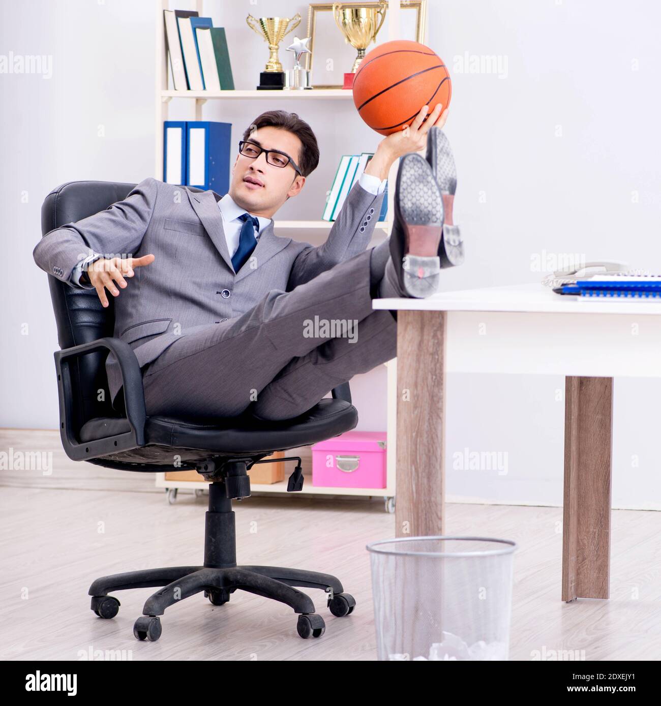 The young businessman playing basketball in office during break Stock ...