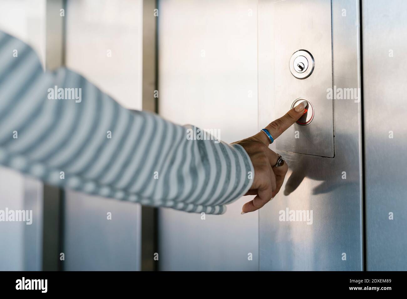 Hand of woman pressing lift button at station Stock Photo - Alamy
