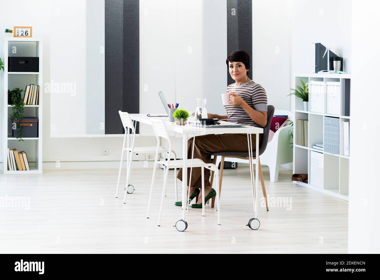 Portrait of businesswoman working alone at office table Stock Photo - Alamy