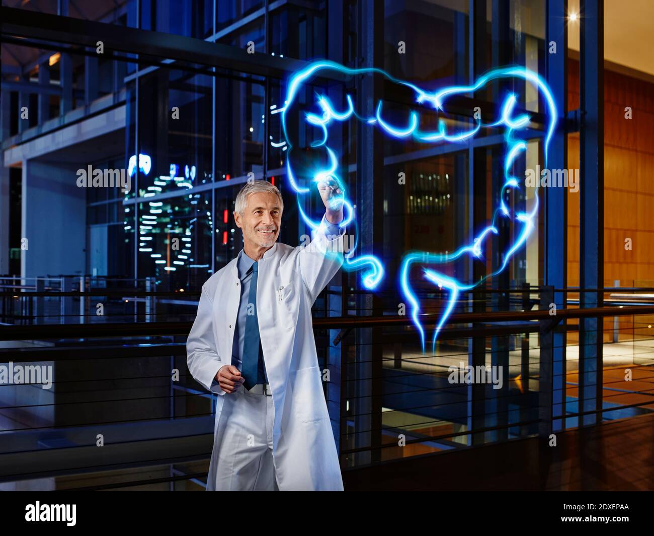 Smiling male gastroenterologist examining large intestine with light ...