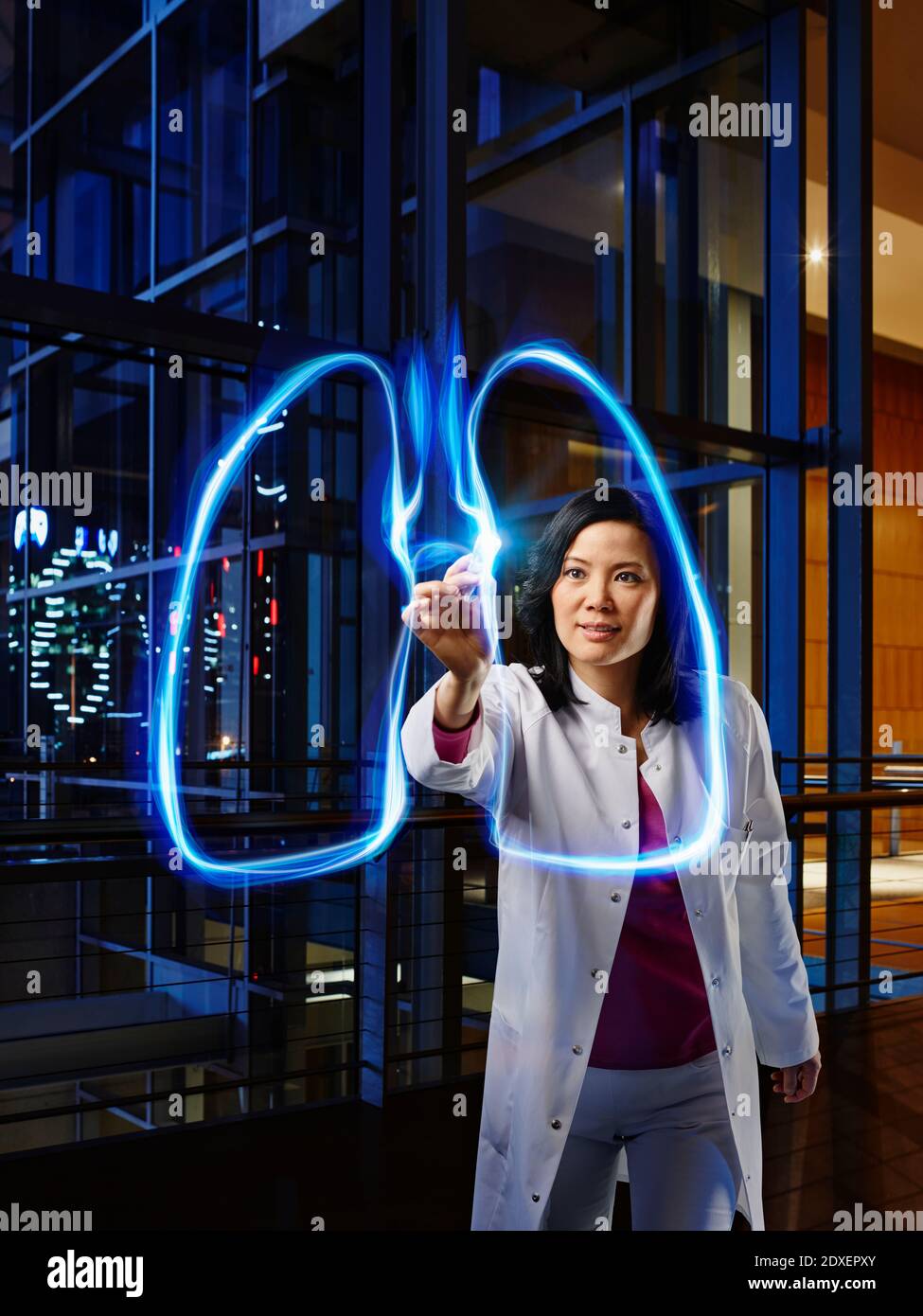 Mature female pulmonologist light painting lung in laboratory at ...