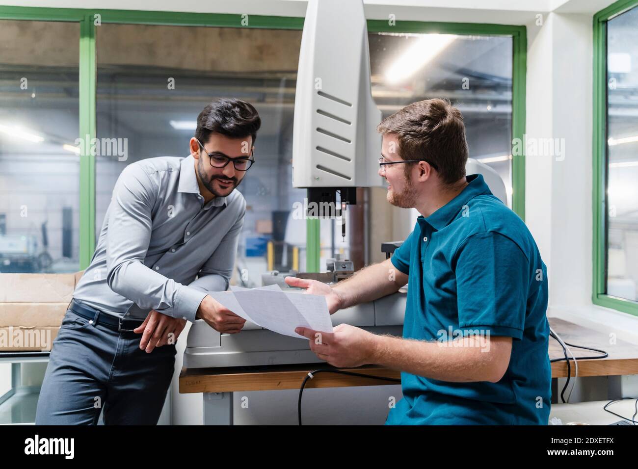 Businessman with male colleague discussing in manufacturing industry ...