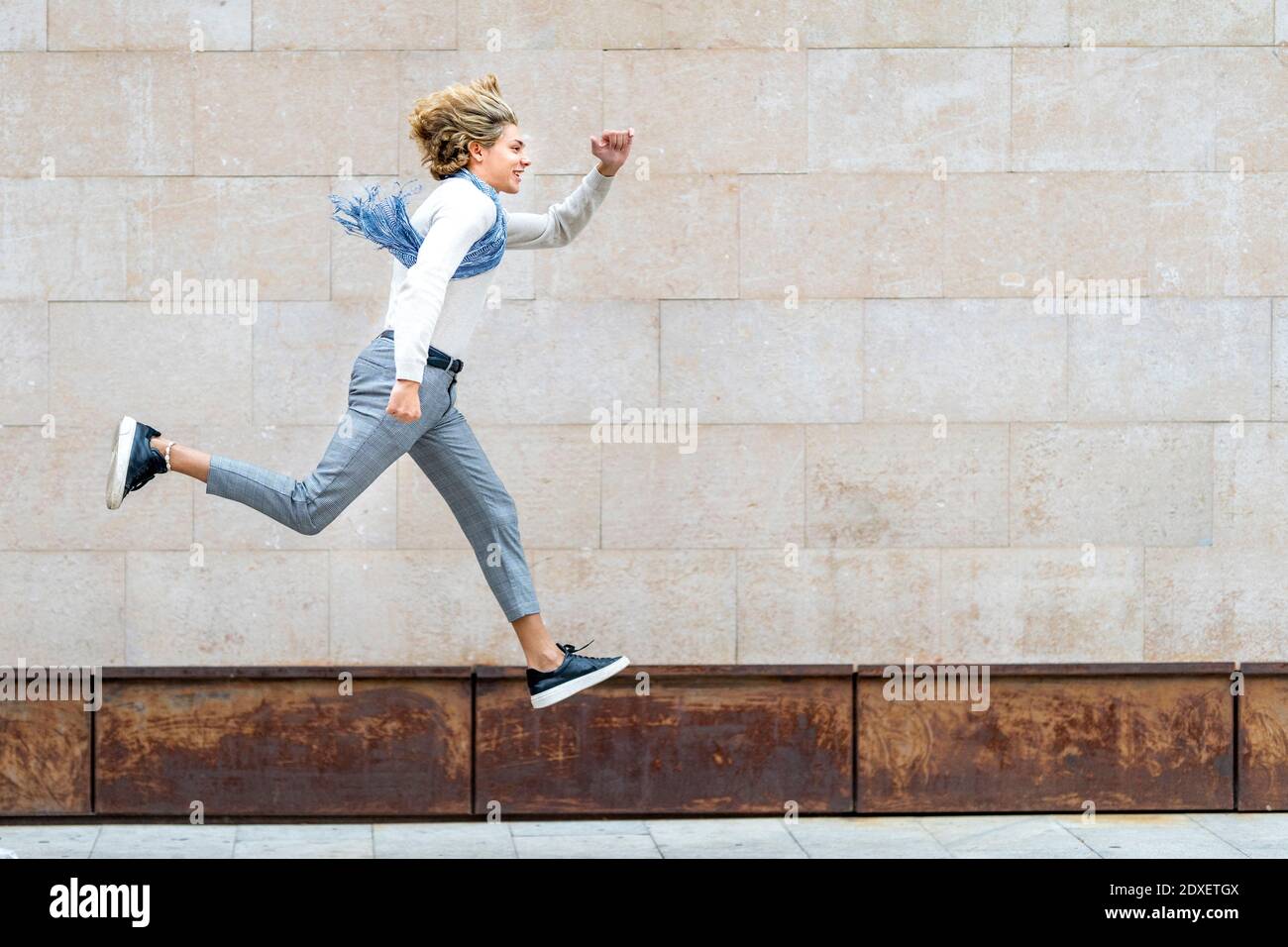 Carefree young man running against wall Stock Photo - Alamy