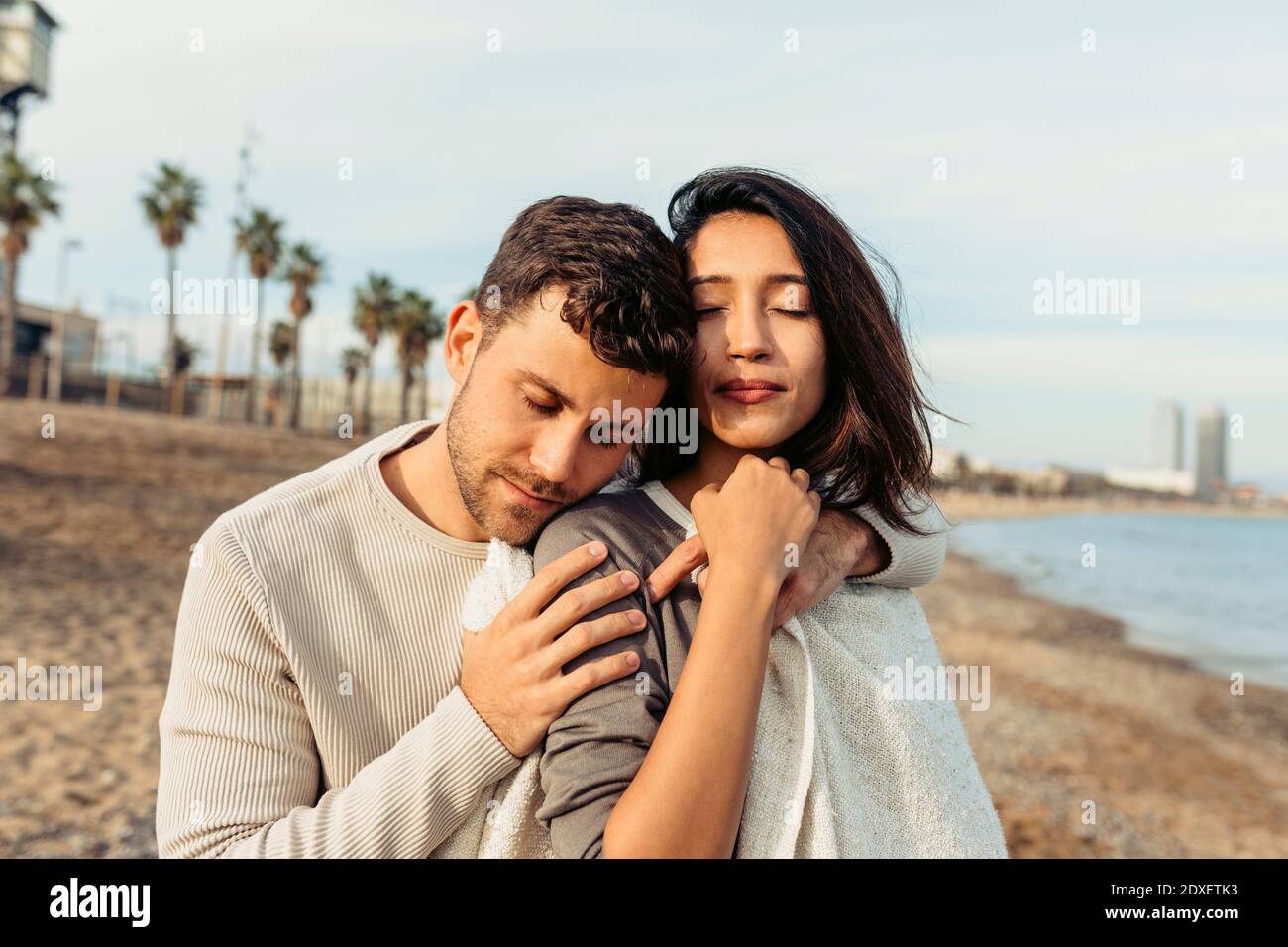 Boyfriend embracing girlfriend against sky at beach Stock Photo - Alamy