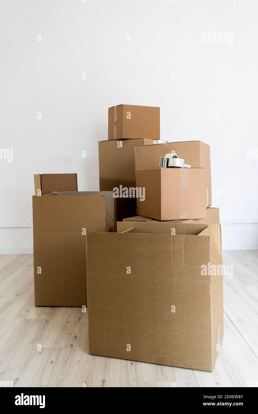 Stack of cardboard boxes against wall in empty room Stock Photo - Alamy