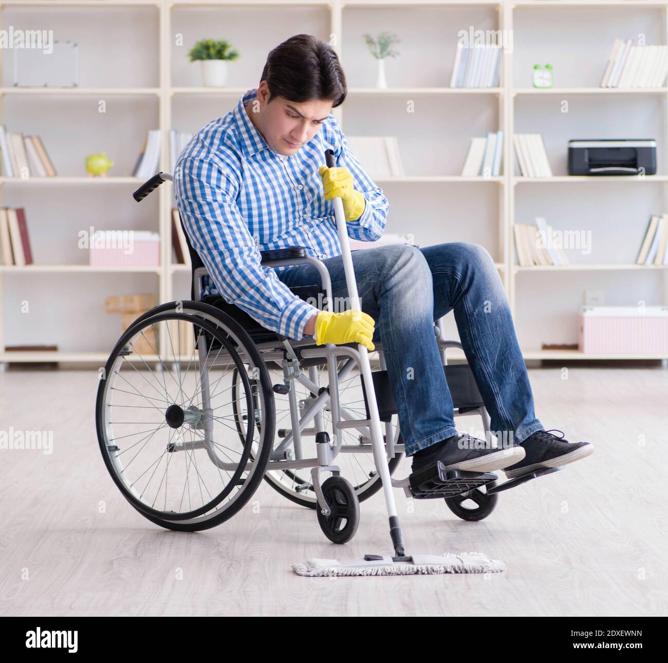 The disabled man on wheelchair cleaning home Stock Photo - Alamy