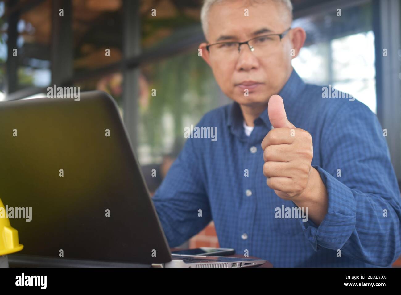 Close up senior man thump up hand success and use computer notebook in ...