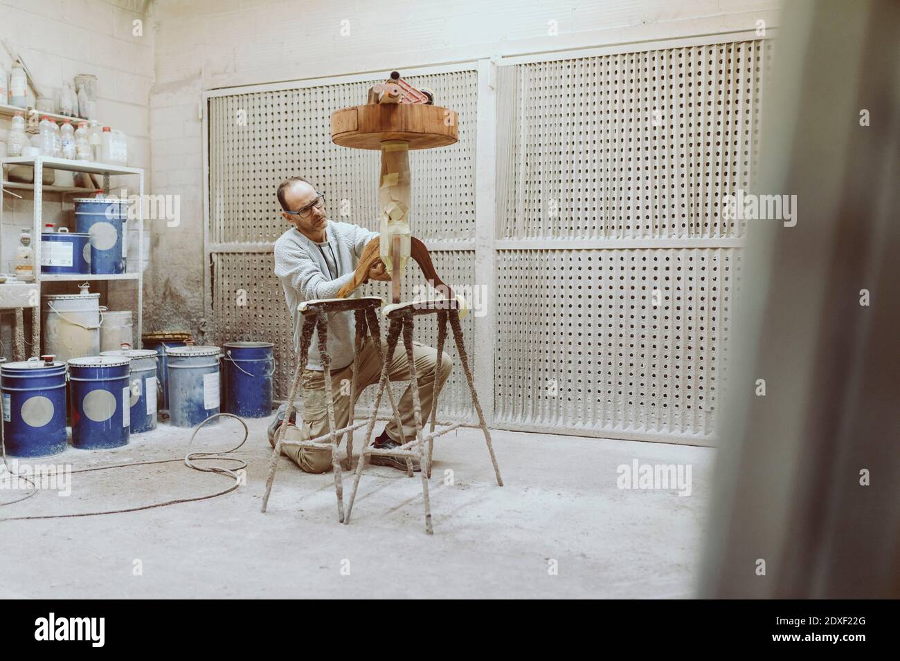 Craftsman polishing table while kneeling at workshop Stock Photo - Alamy