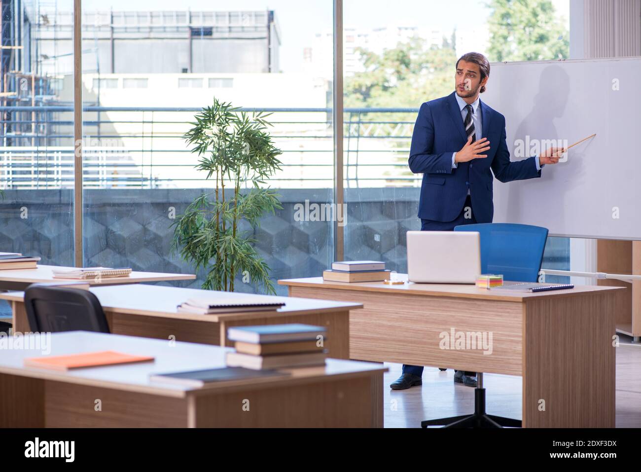 Young teacher in suit in the classroom Stock Photo - Alamy