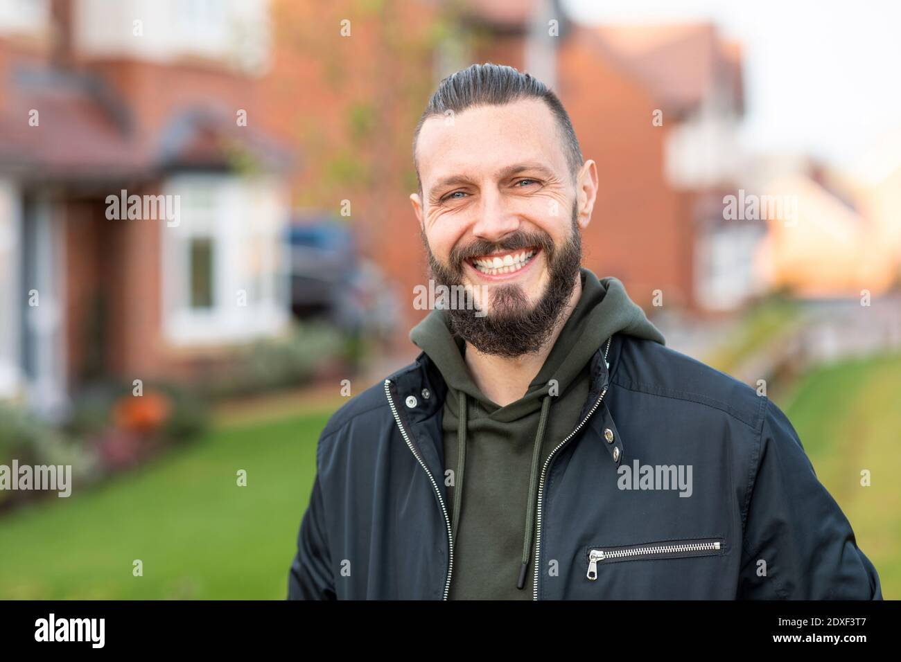 Happy bearded man standing in front yard Stock Photo - Alamy