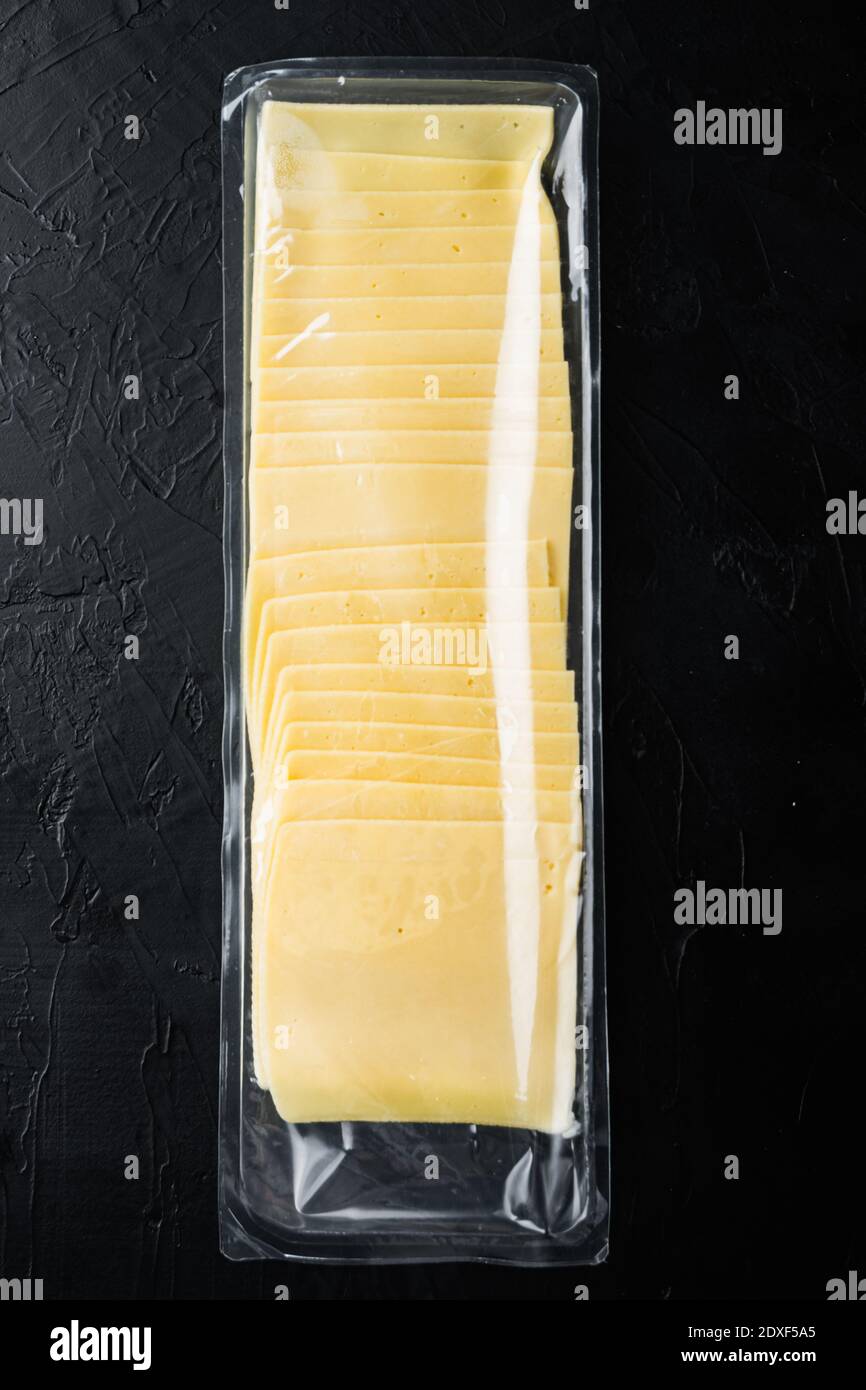Slices of american cheese plastic pack, on black background Stock Photo ...
