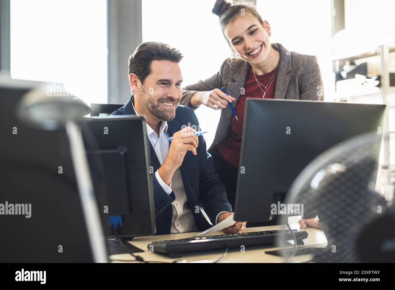 Business people using computer while working together at office Stock ...