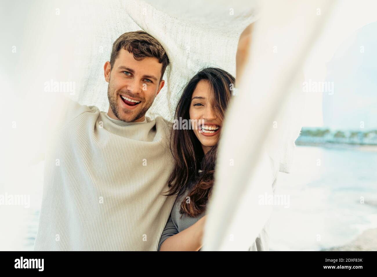 Girlfriend and boyfriend laughing while standing below shawl Stock ...