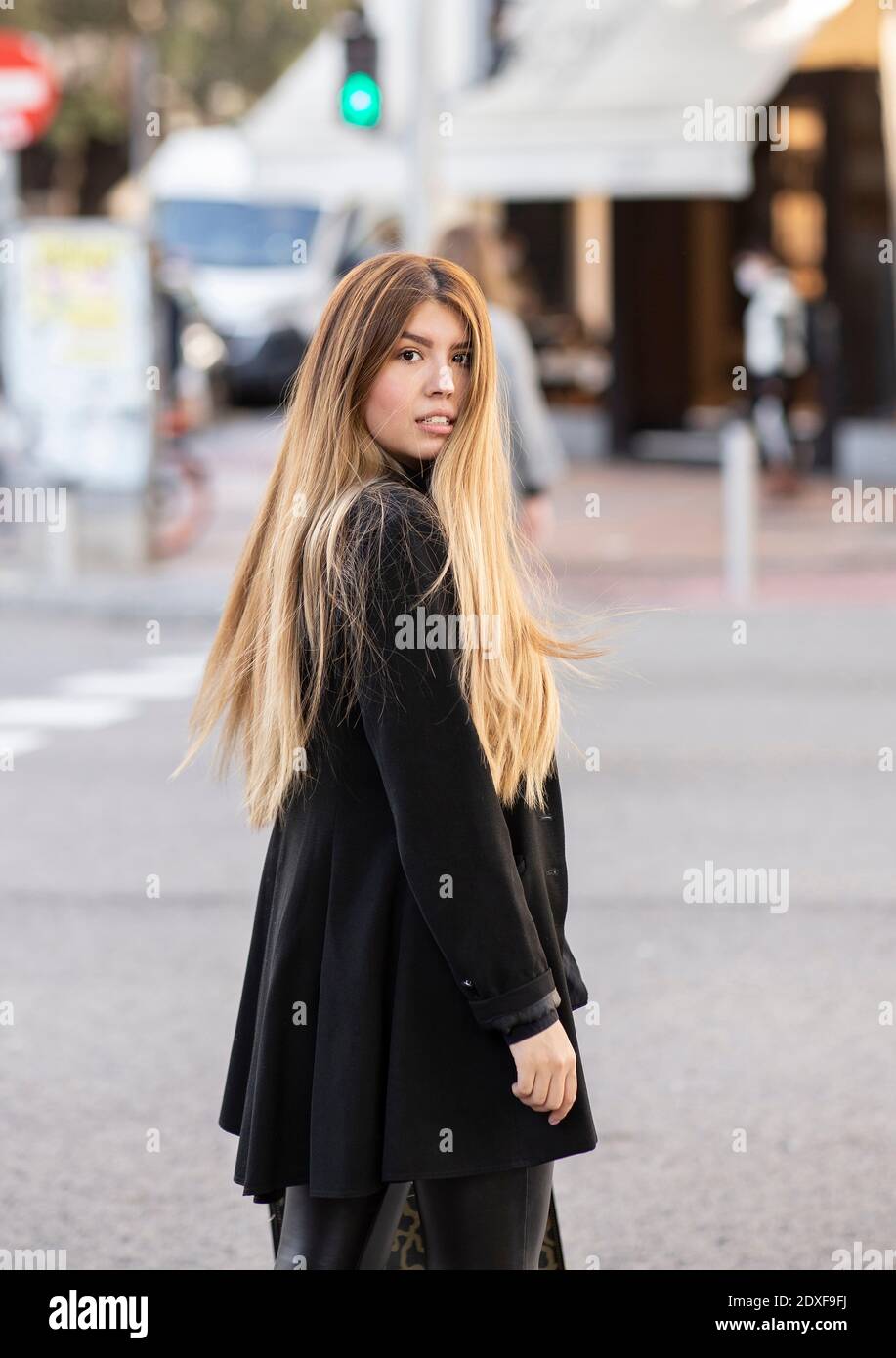 Woman wearing jacket standing on street in city Stock Photo - Alamy