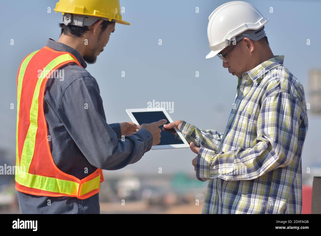 Two Engineering using tablet technology checking inspection work ...