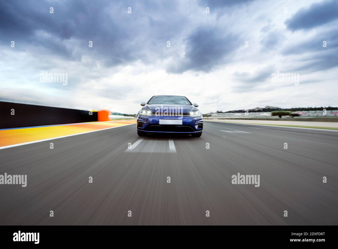 Blue sports car racing on asphalt track Stock Photo - Alamy