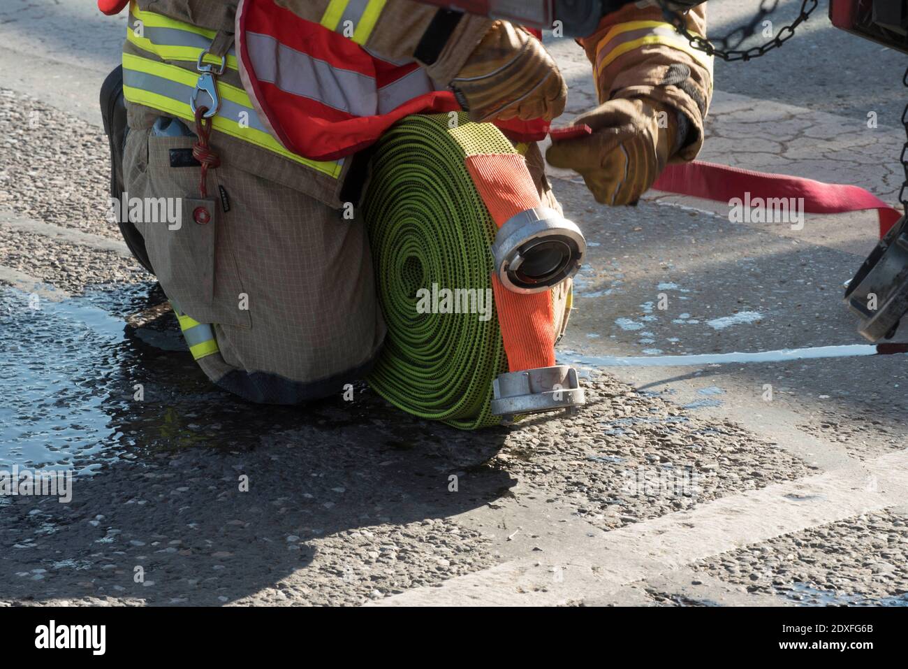 Low Section Of Firefighter Holding Fire Hose On Road Stock Photo - Alamy