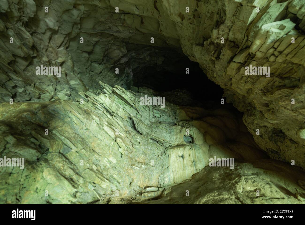 Inside a dark wet cave with the illuminated exit in sight Stock Photo ...