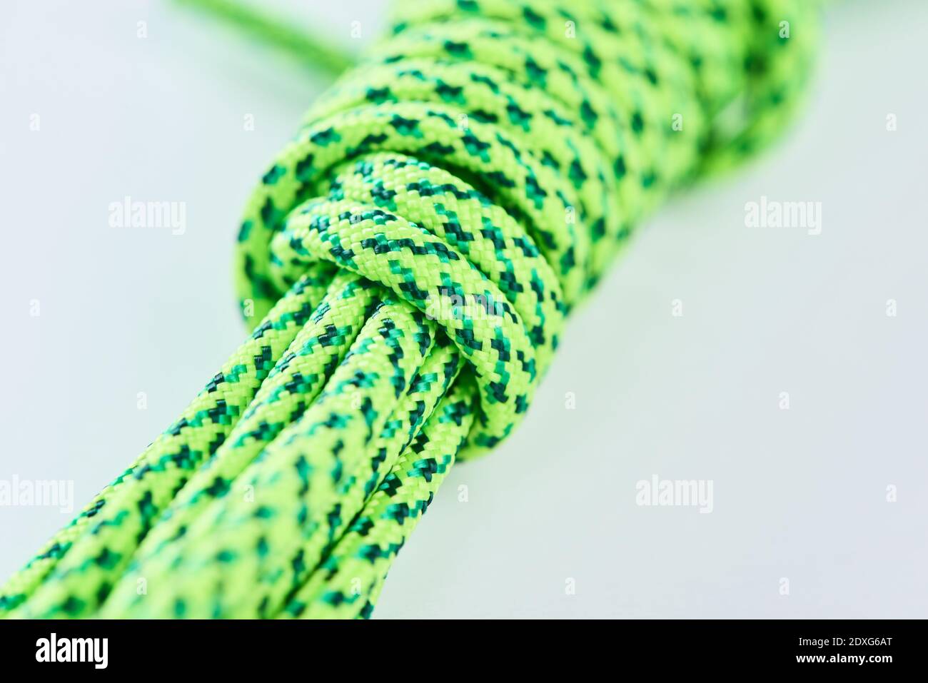 Close-up on coiled green paracord on white background Stock Photo - Alamy