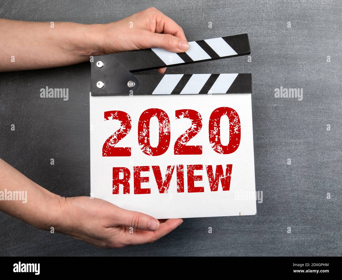 2020 Review. Business concept. Movie clapper in woman hand. Black chalk ...