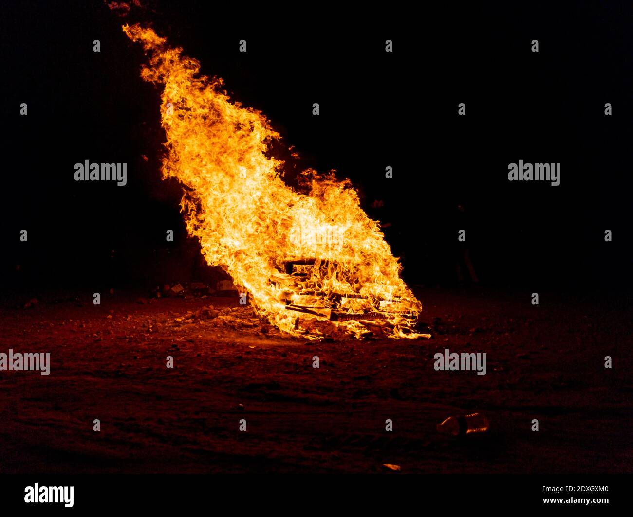 Large flame erupting from small campfire at night Stock Photo - Alamy