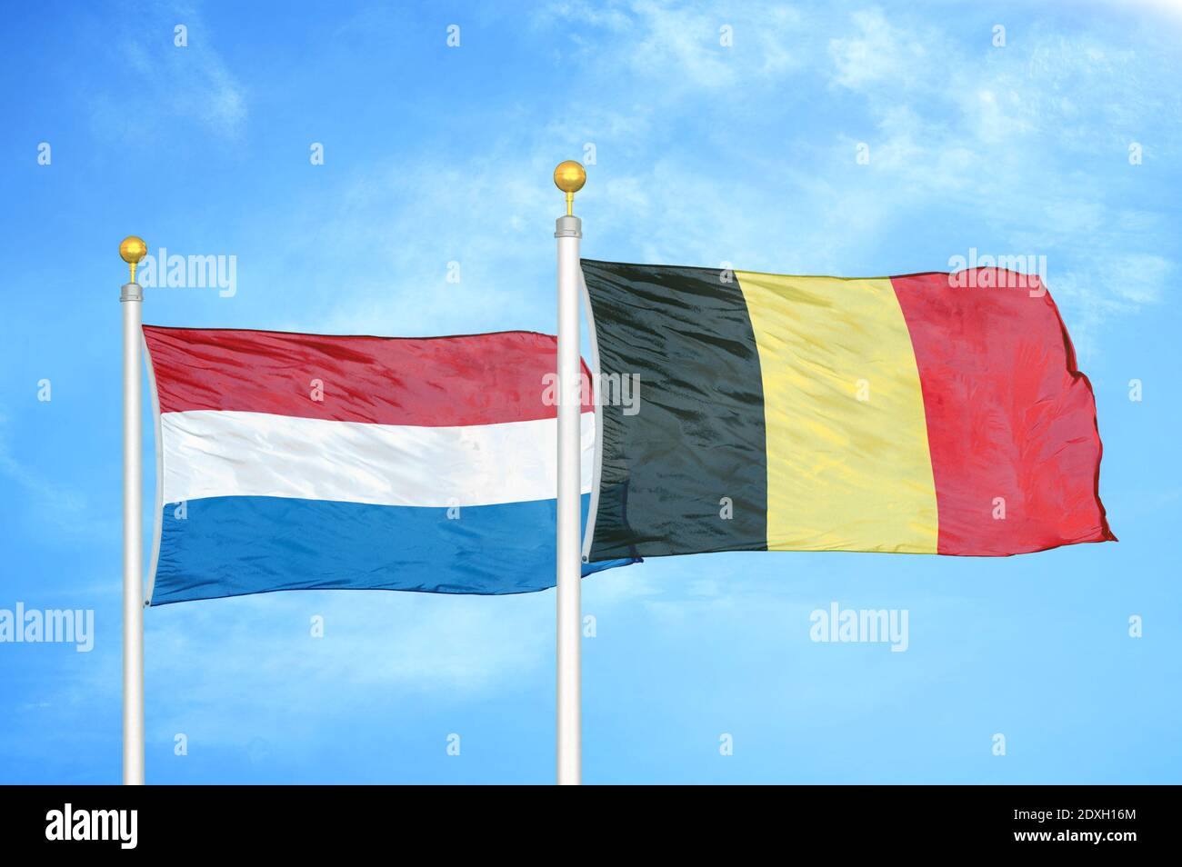 Netherlands and Belgium two flags on flagpoles and blue sky Stock Photo ...