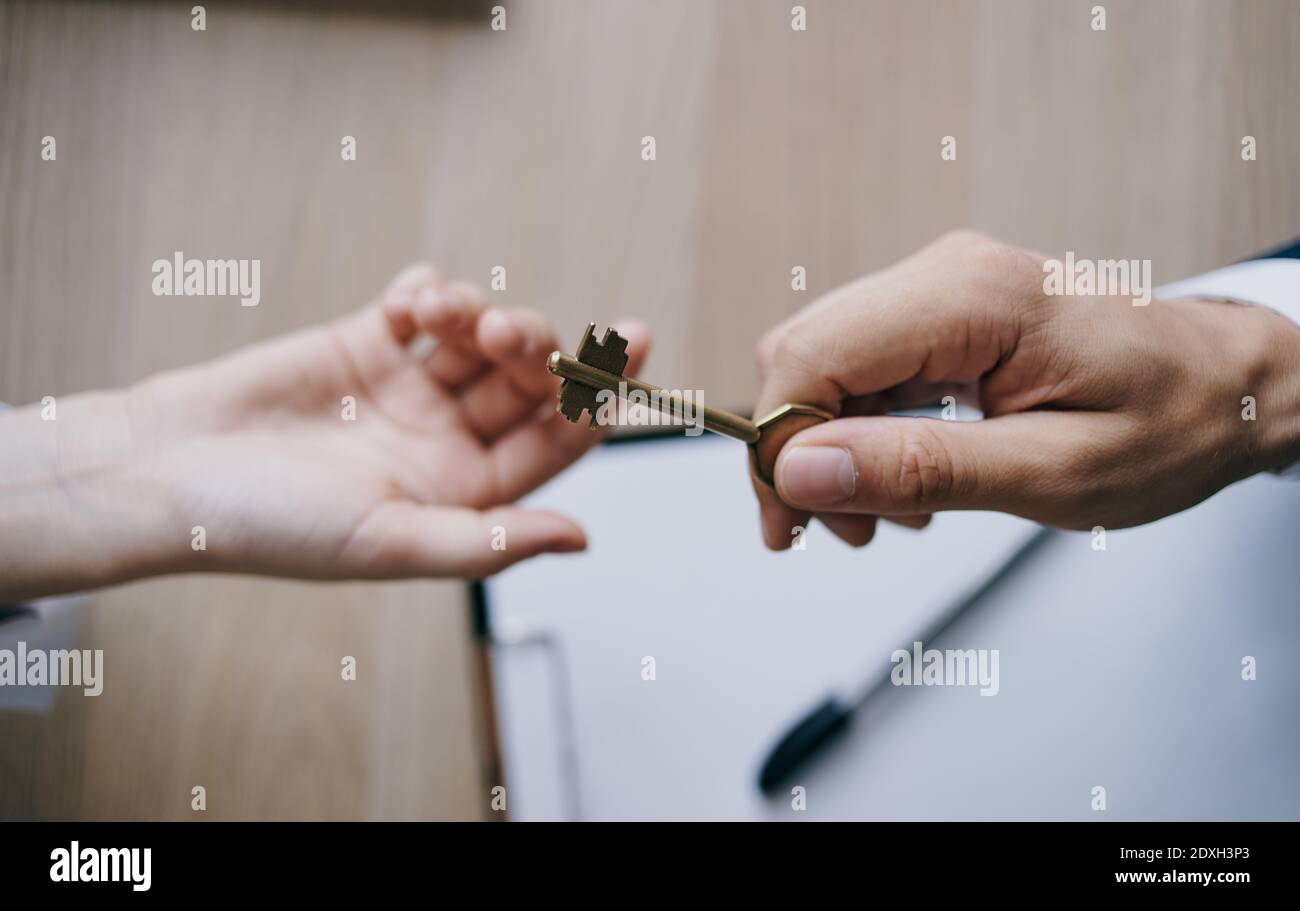 handing the key from hand to hand in the office business finance work ...