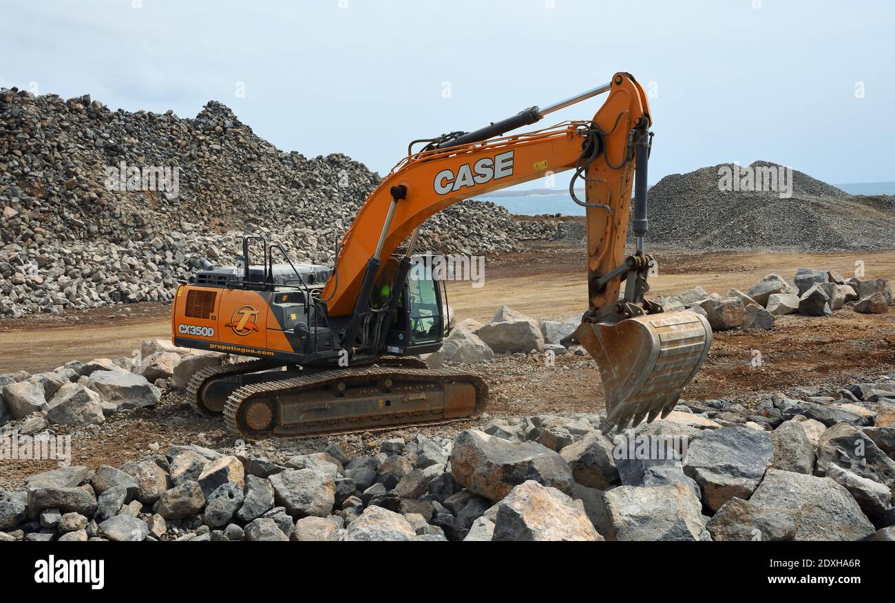 Digger moving large boulders on construction site Stock Photo - Alamy