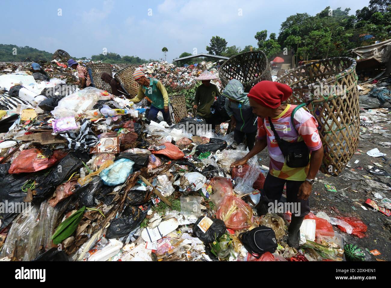 Scavengers are active in piles of rubbish in the landfill (TPA) of ...