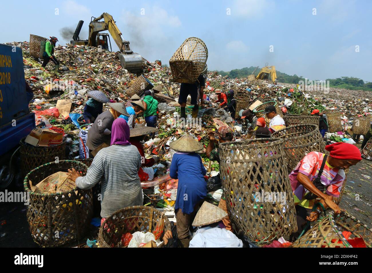 Scavengers are active in piles of rubbish in the landfill (TPA) of ...