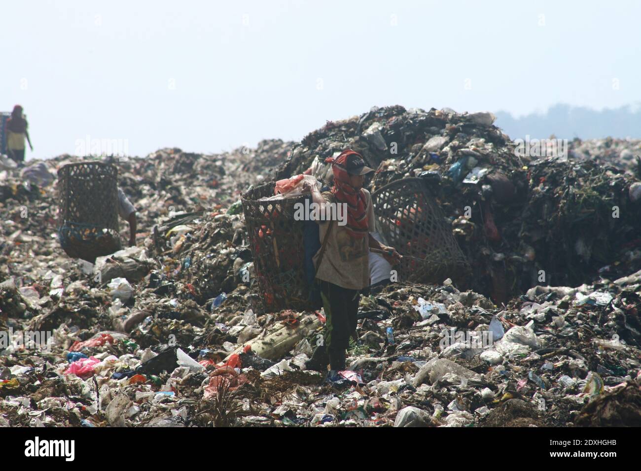 Scavengers are active in piles of rubbish in the landfill (TPA) of ...