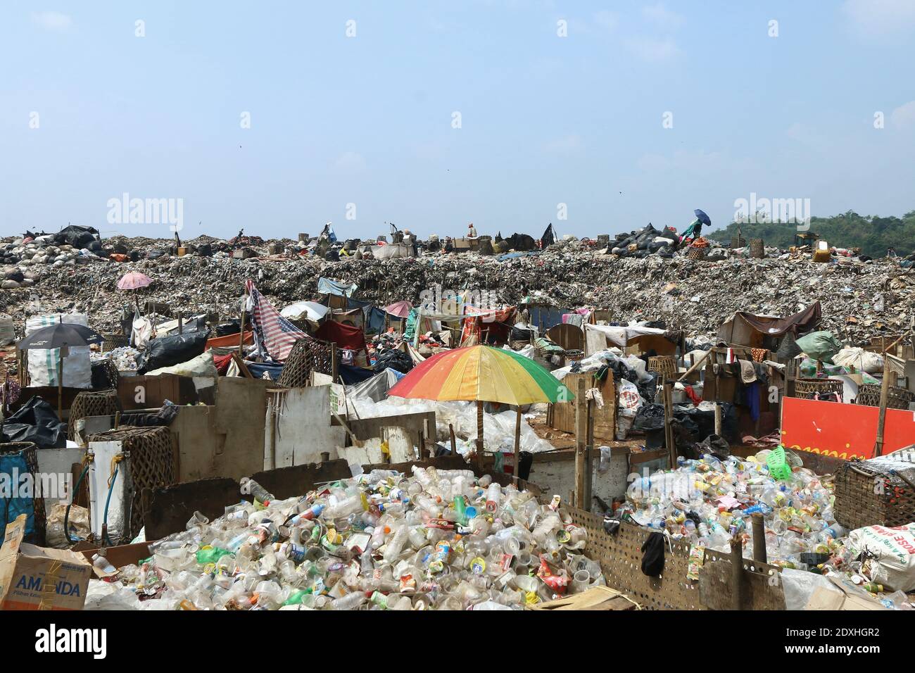 Scavengers are active in piles of rubbish in the landfill (TPA) of ...