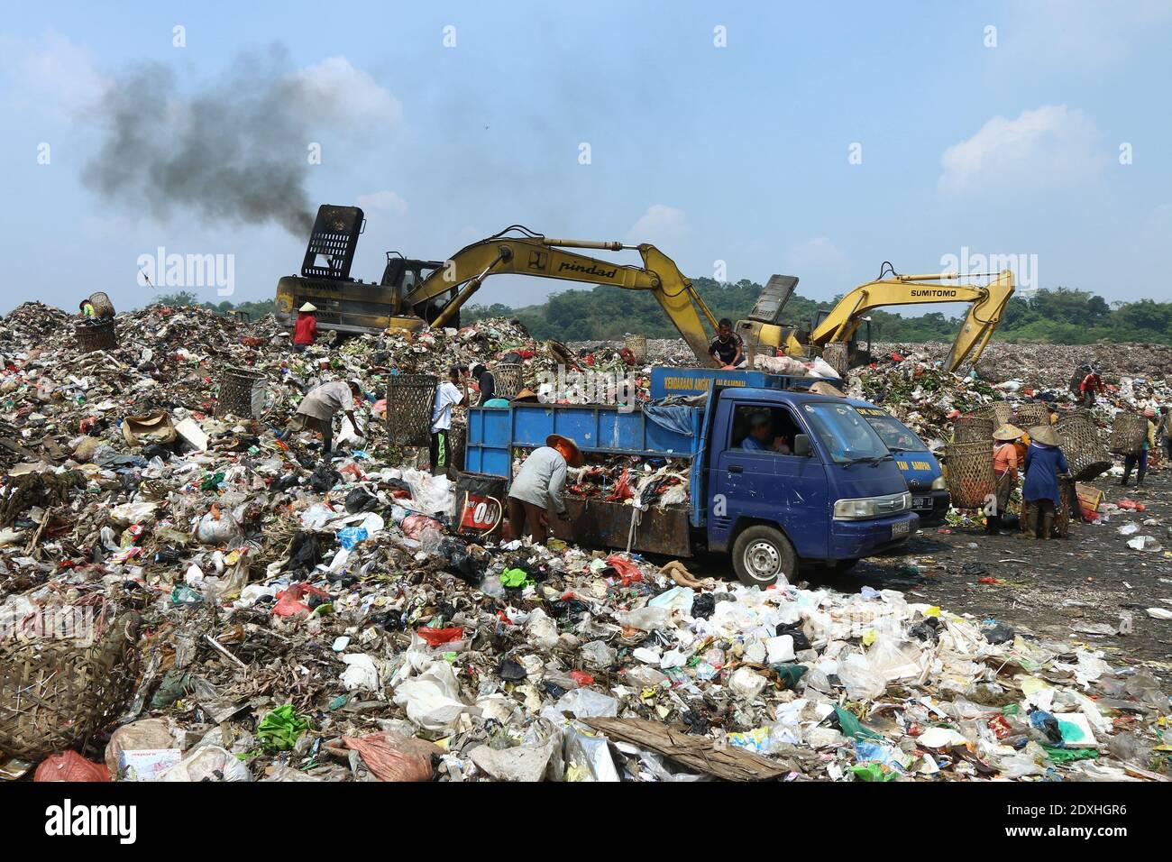 Scavengers are active in piles of rubbish in the landfill (TPA) of ...