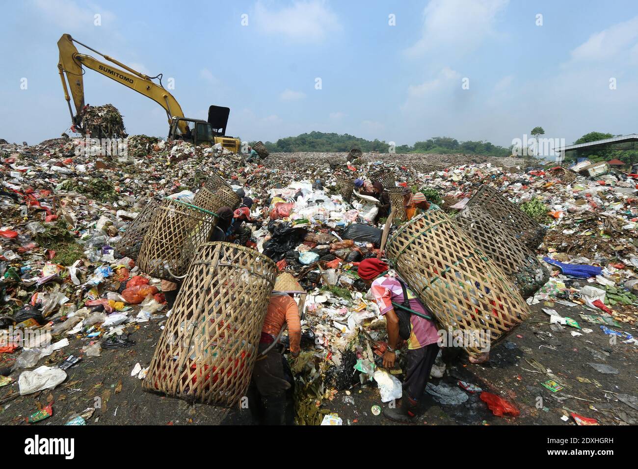 Scavengers are active in piles of rubbish in the landfill (TPA) of ...