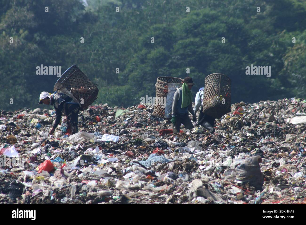 Scavengers are active in piles of rubbish in the landfill (TPA) of ...