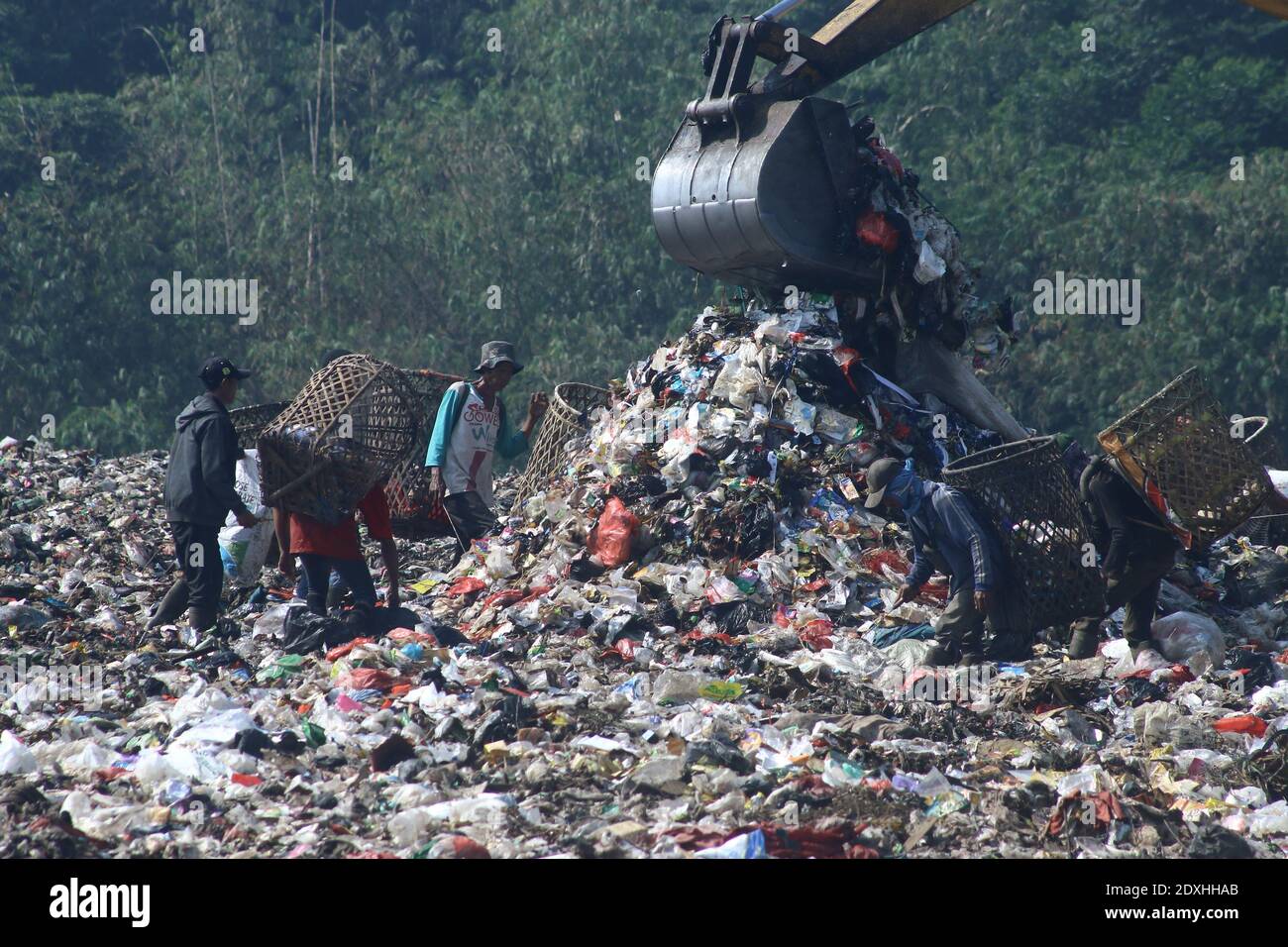 Scavengers are active in piles of rubbish in the landfill (TPA) of ...
