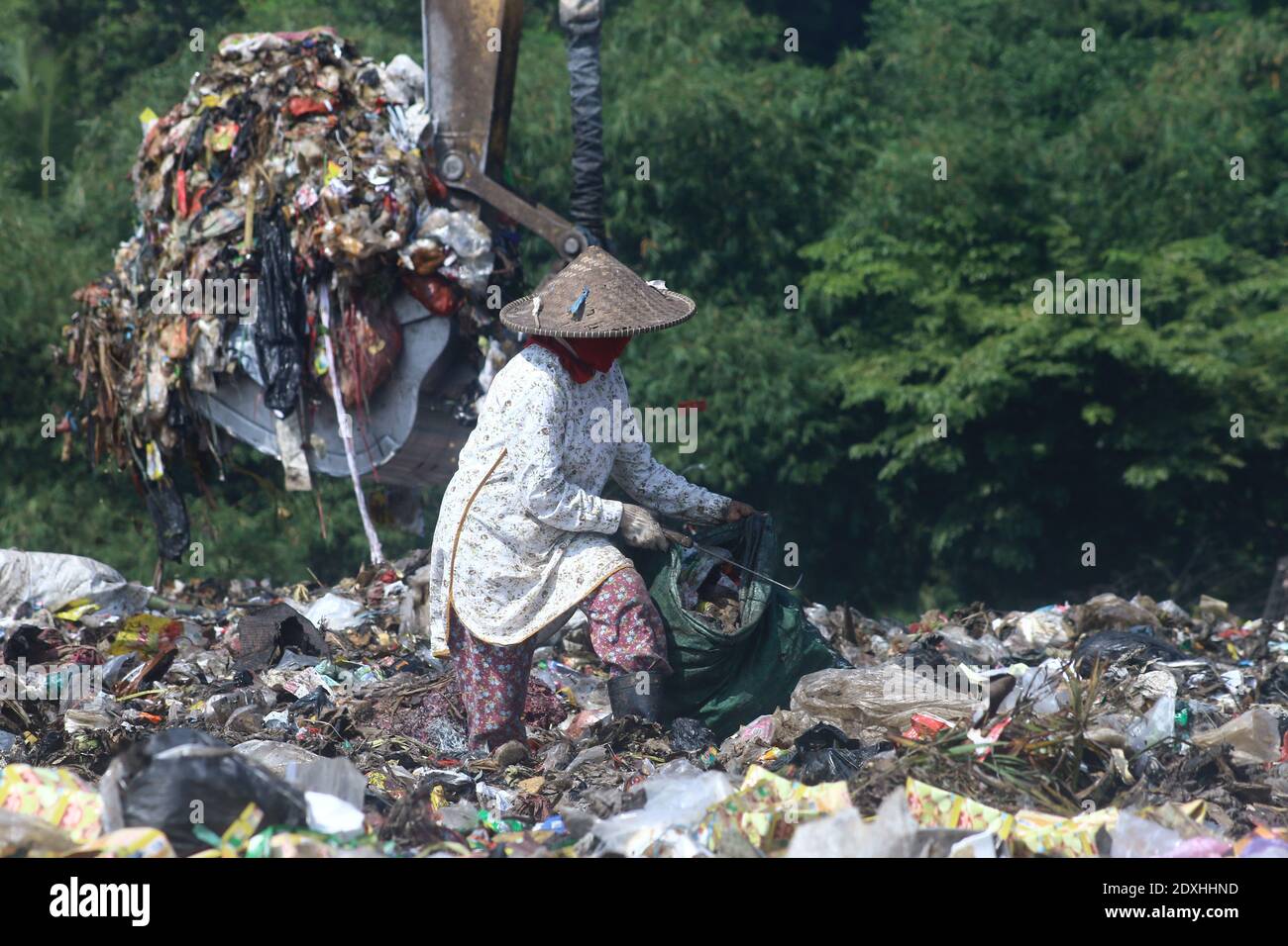 Scavengers are active in piles of rubbish in the landfill (TPA) of ...