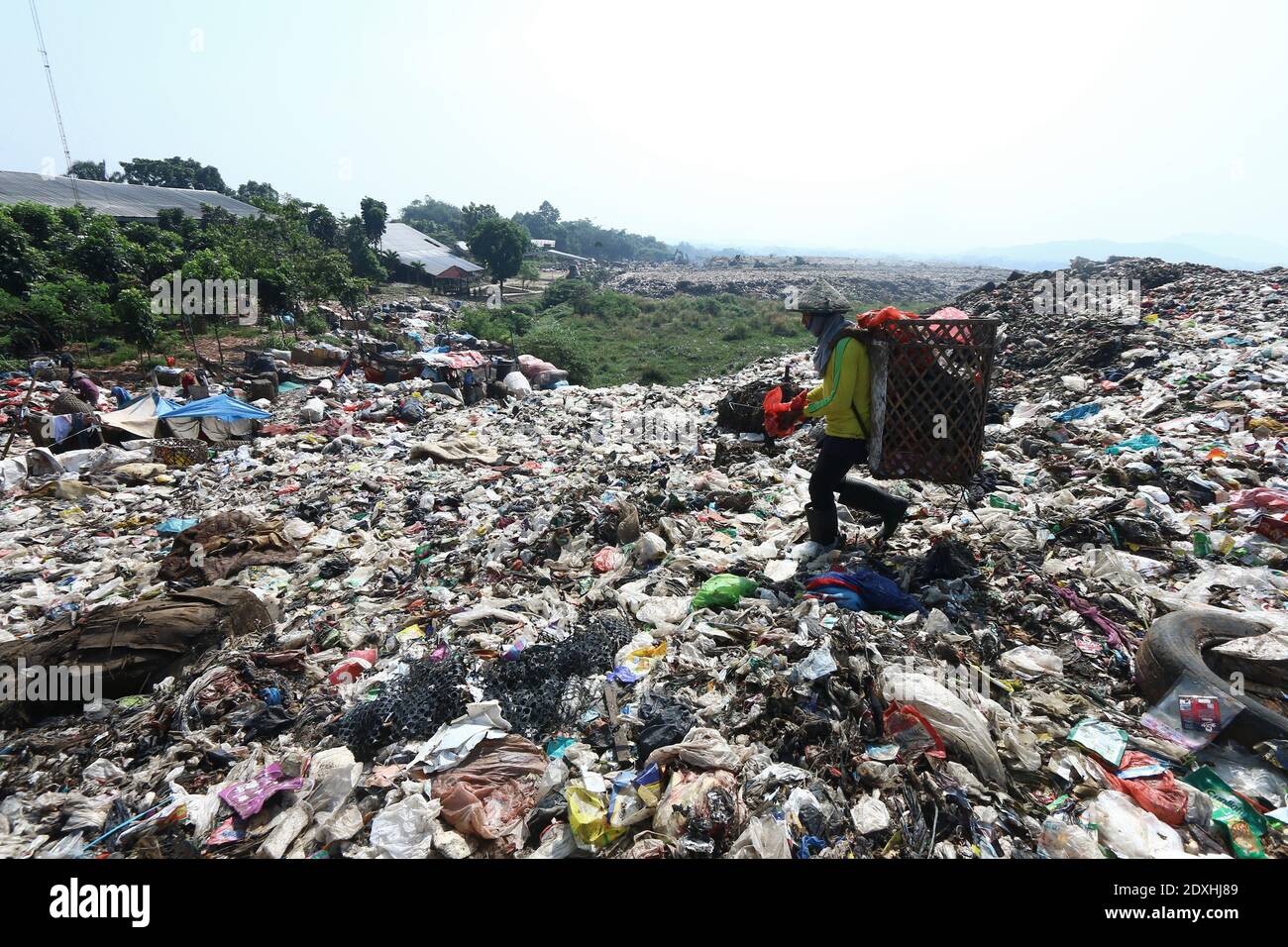 Scavengers are active in piles of rubbish in the landfill (TPA) of ...