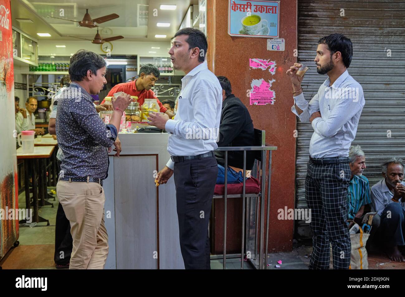 Tea drinking traders standing outside a small tea shop in Kalbadevi ...
